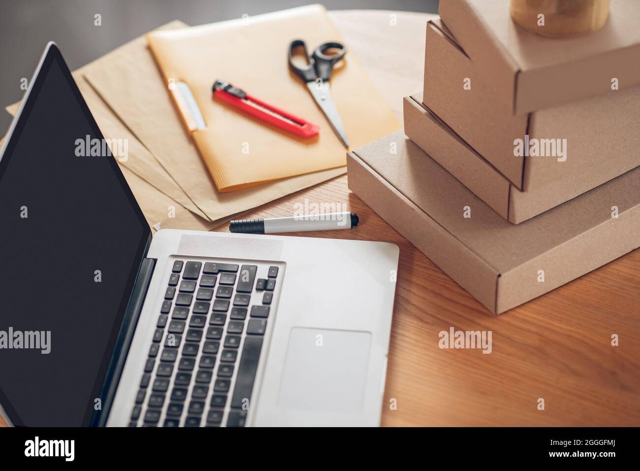 Laptop and product packages stacked on the desk Stock Photo - Alamy