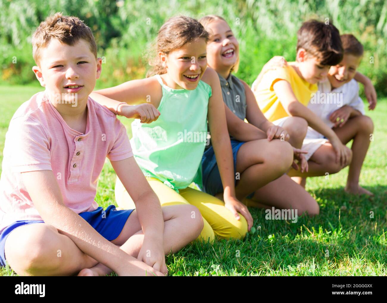 Kids sitting on grass Stock Photo - Alamy