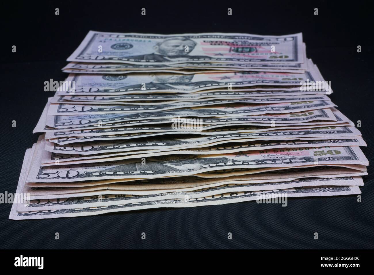 Stack of US 50 dollar bills on black background Stock Photo - Alamy