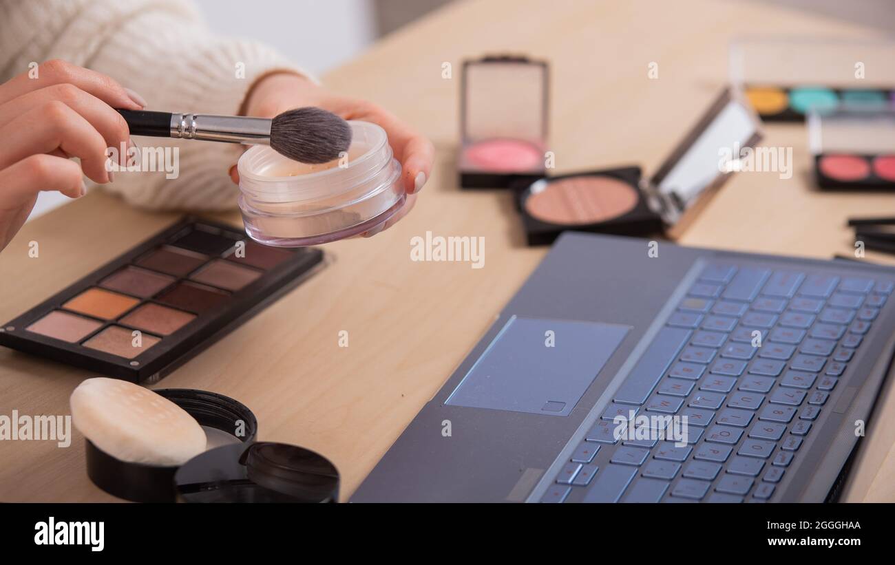 A faceless woman watches online training from a professional makeup ...