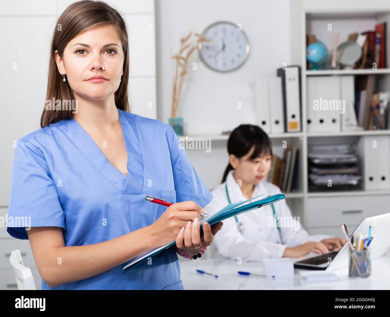 Doctor writing notes on clipboard Stock Photo - Alamy