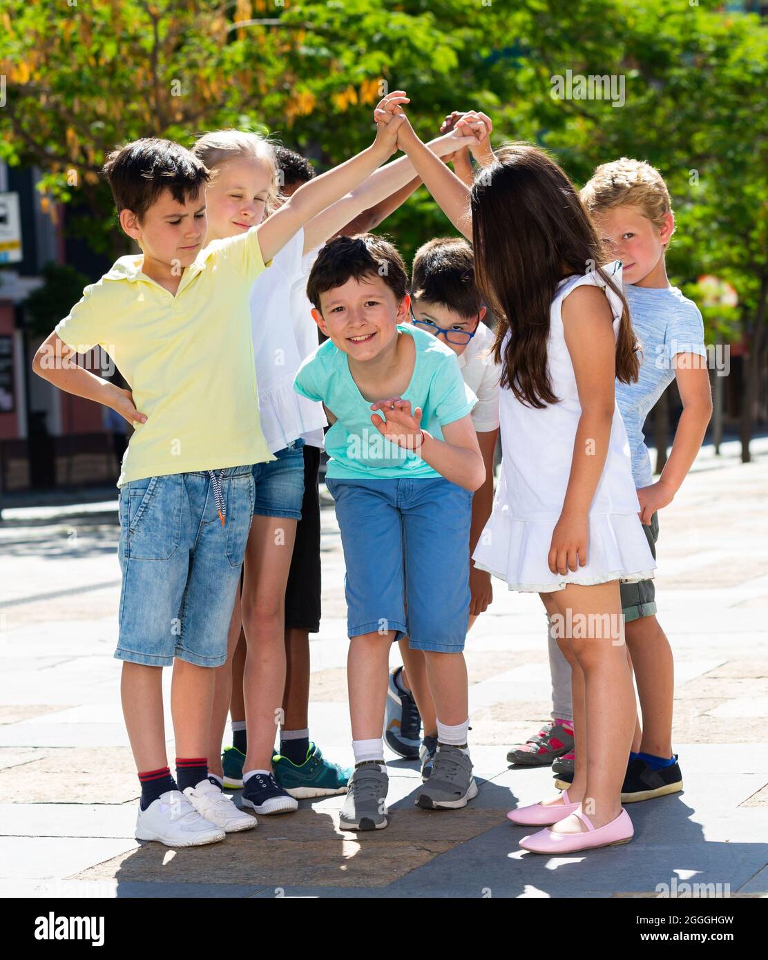 Group of positive children holding hands up and playing together Stock ... Group of positive children holding hands up and playing together Stock ...