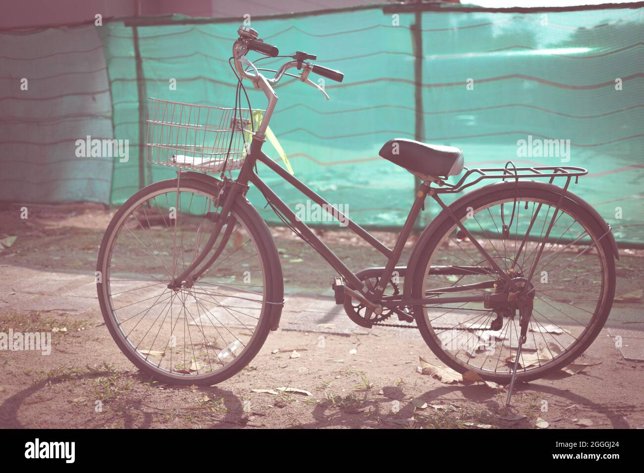 Black vintage bicycle on the sand with green background Stock Photo - Alamy