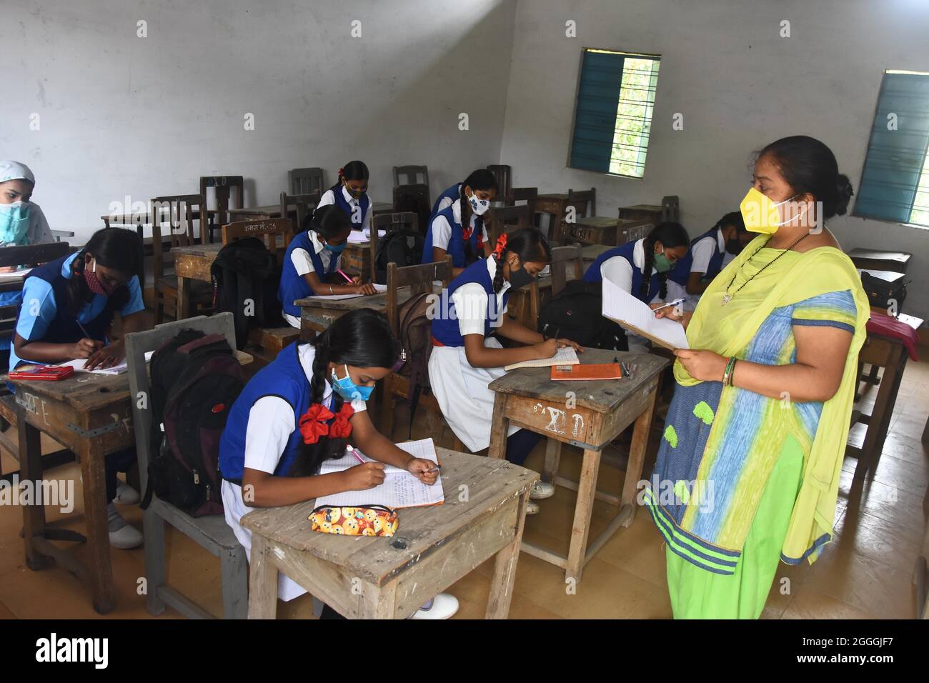 Students wearing facemasks maintain social distance while attending ...
