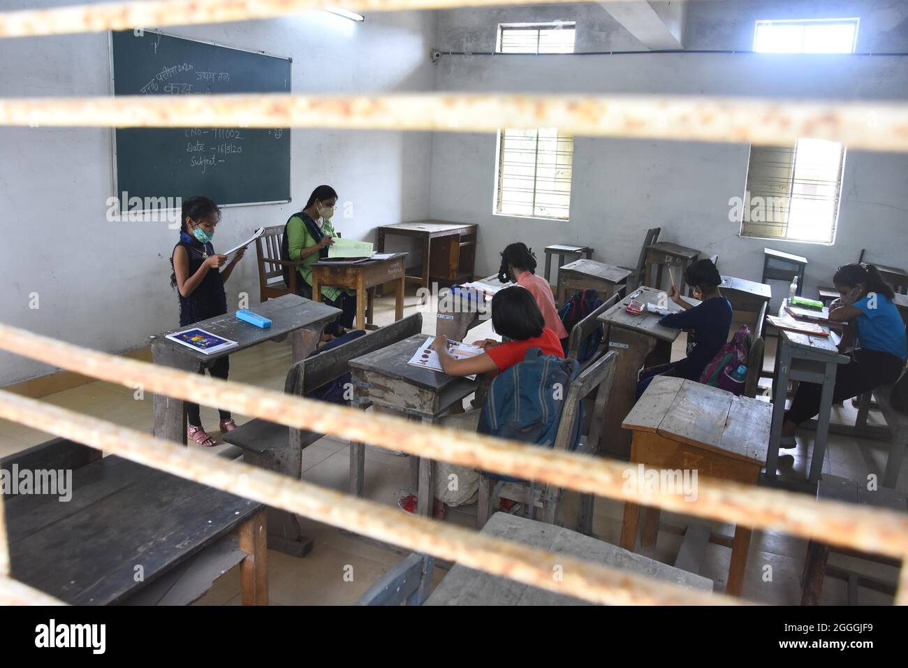 Students wearing facemasks maintain social distance while attending ...