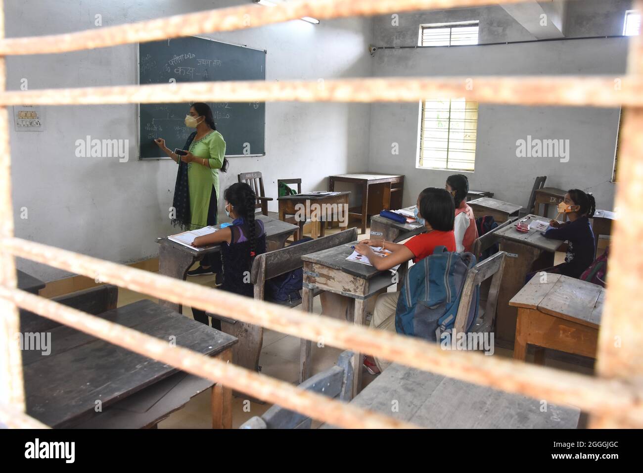 Students wearing facemasks maintain social distance while attending ...