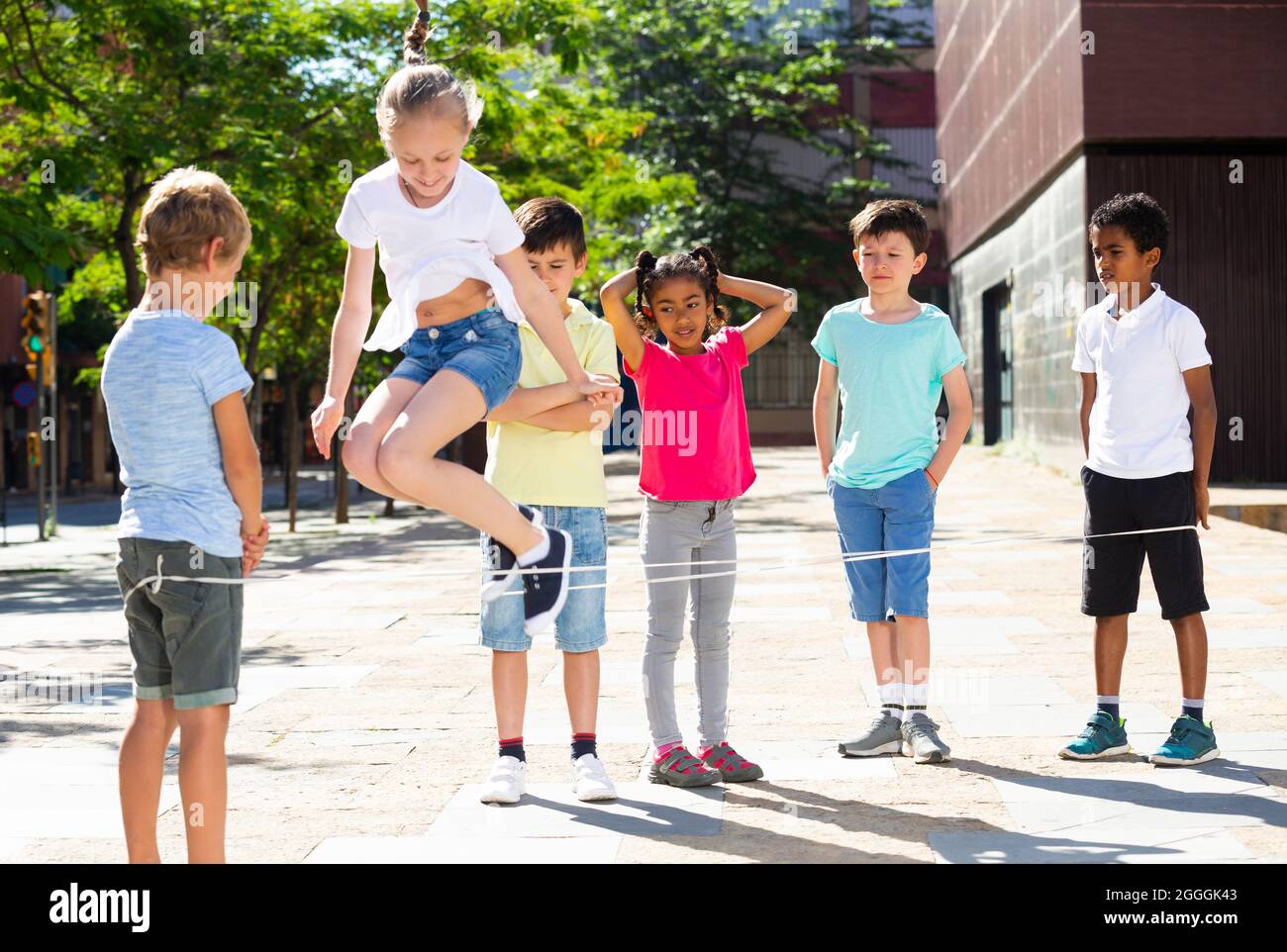 Happy children jumping game by rubber band and laughing Stock Photo - Alamy