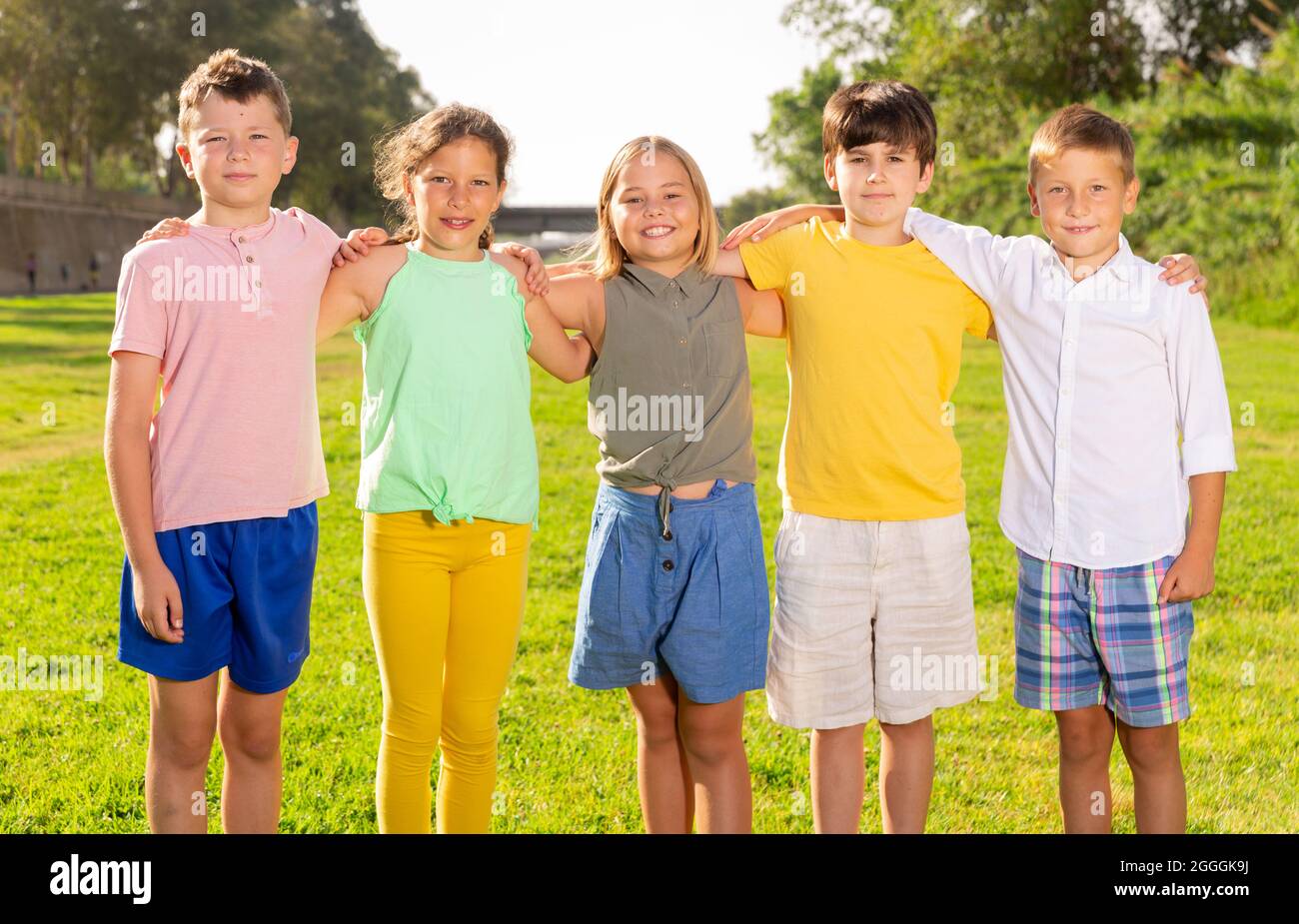 Portrait of five glad children who are walking and posing in park Stock ...