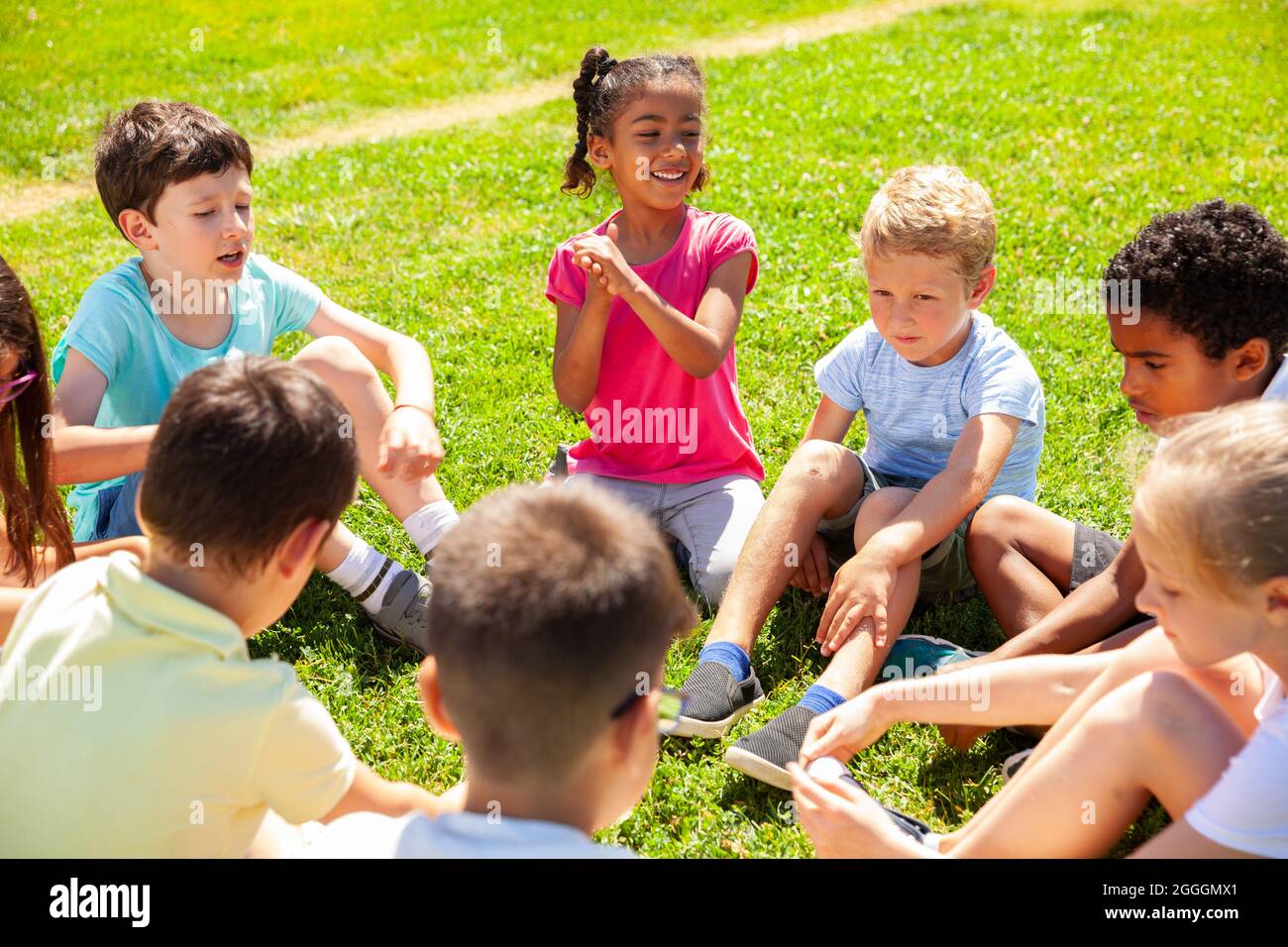 Group of elementary school children chatting on the green lawn Stock ...