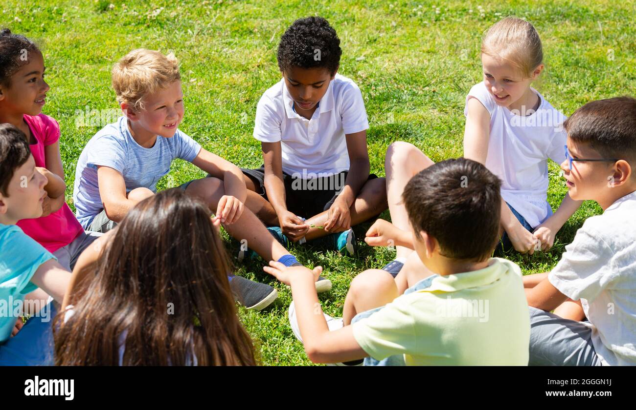 Group of elementary school children chatting on the green lawn Stock ...
