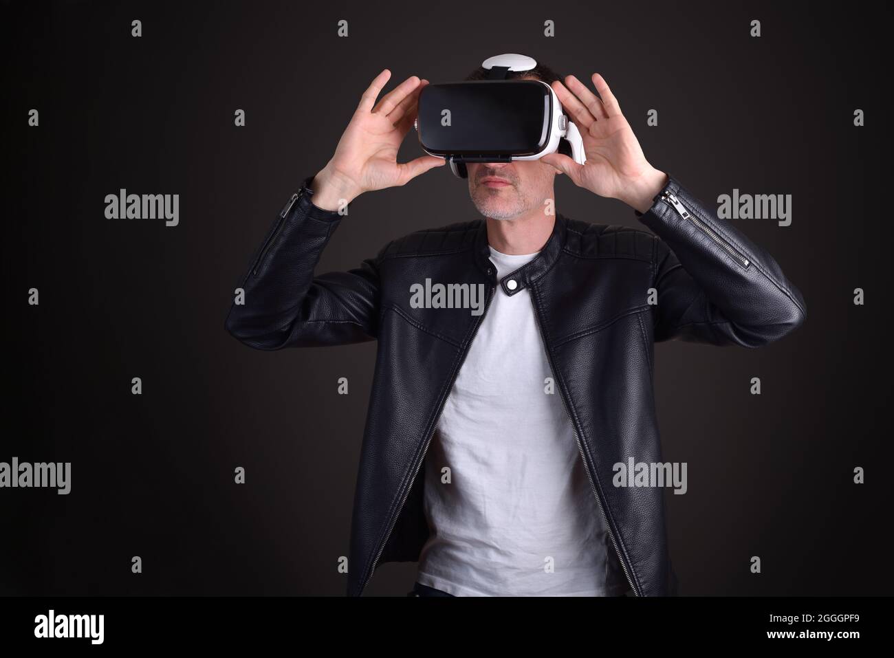 Man in leather jacket interacting with vr glasses black background ...
