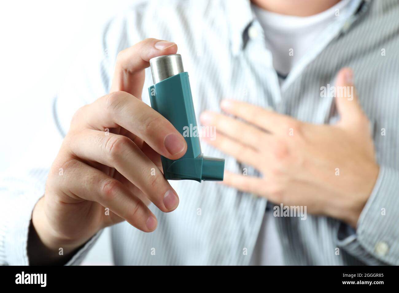Young man holds asthma inhaler during asthma attack Stock Photo - Alamy