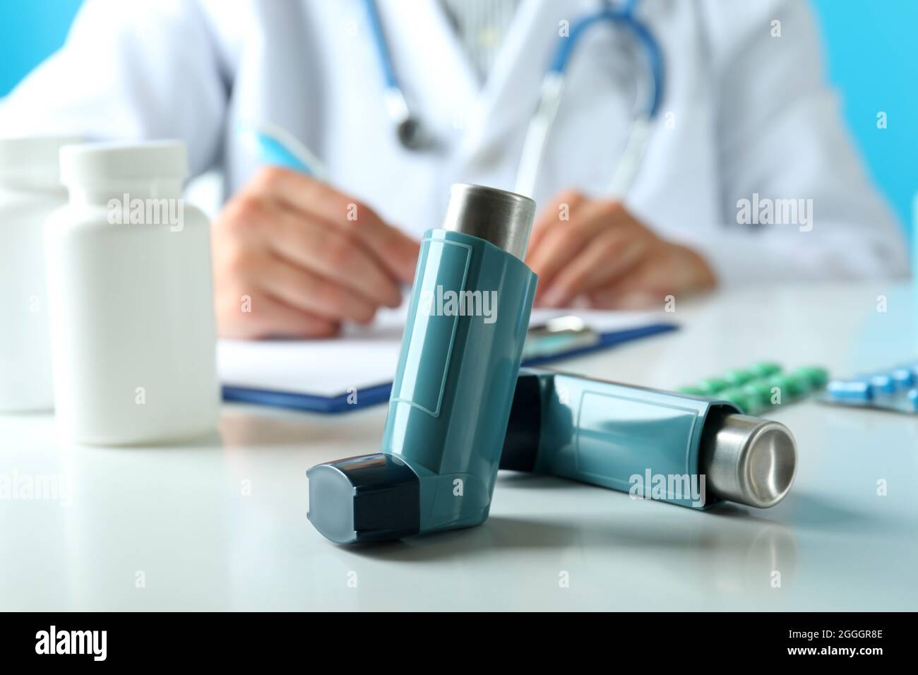 Inhalers against female doctor sitting at the table and writing Stock ...