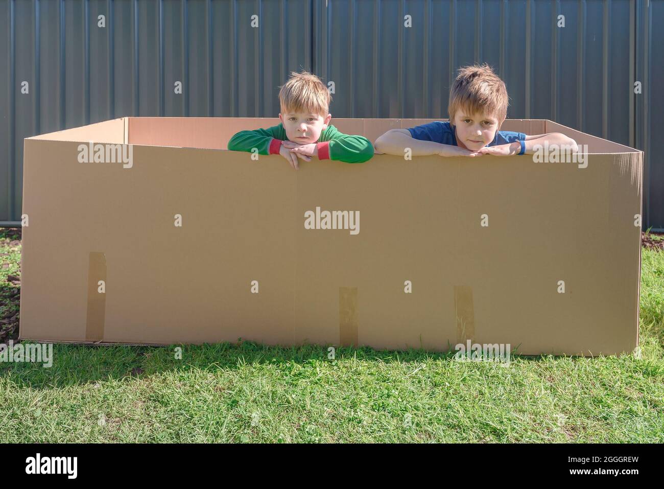 Children sitting inside a big carton box. Thinking out of the box ...