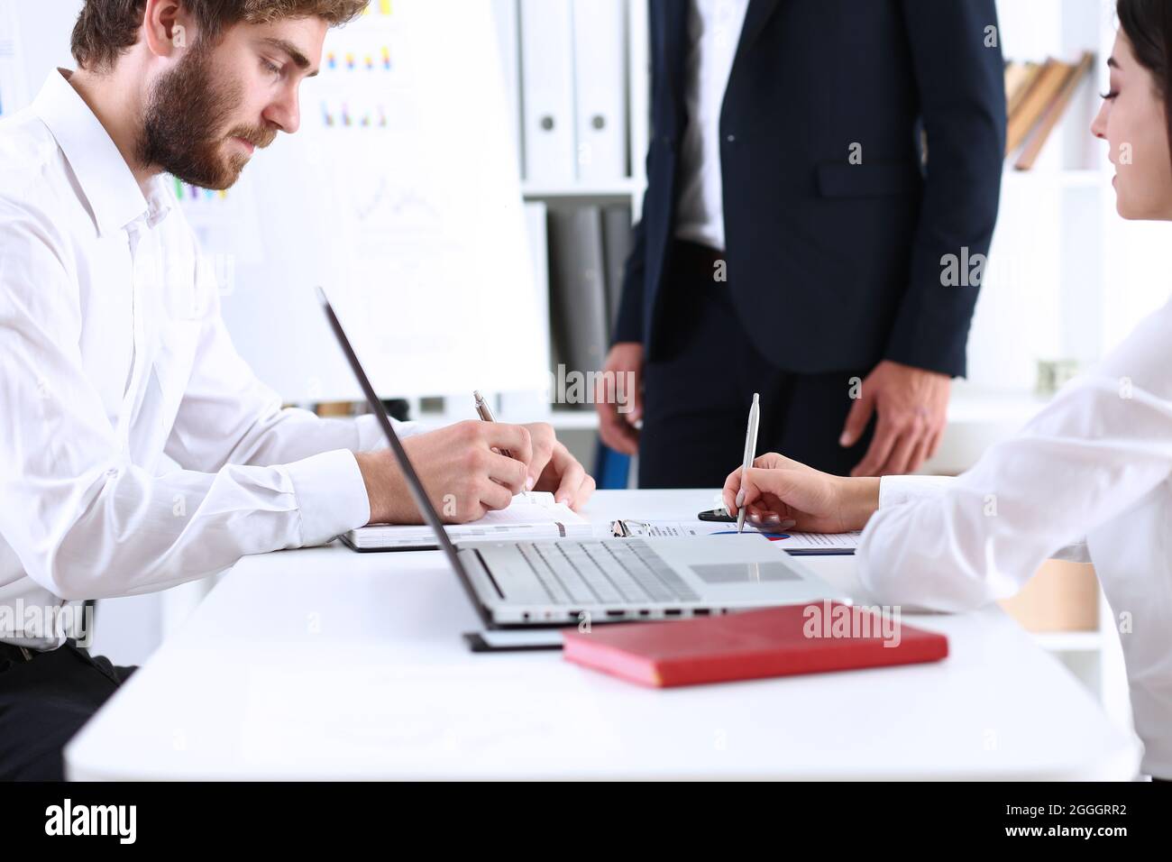 Group of people deliberate on white board problem Stock Photo - Alamy