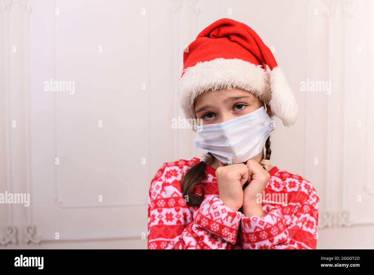 a girl wearing a Santa helper hat and a mask Stock Photo - Alamy