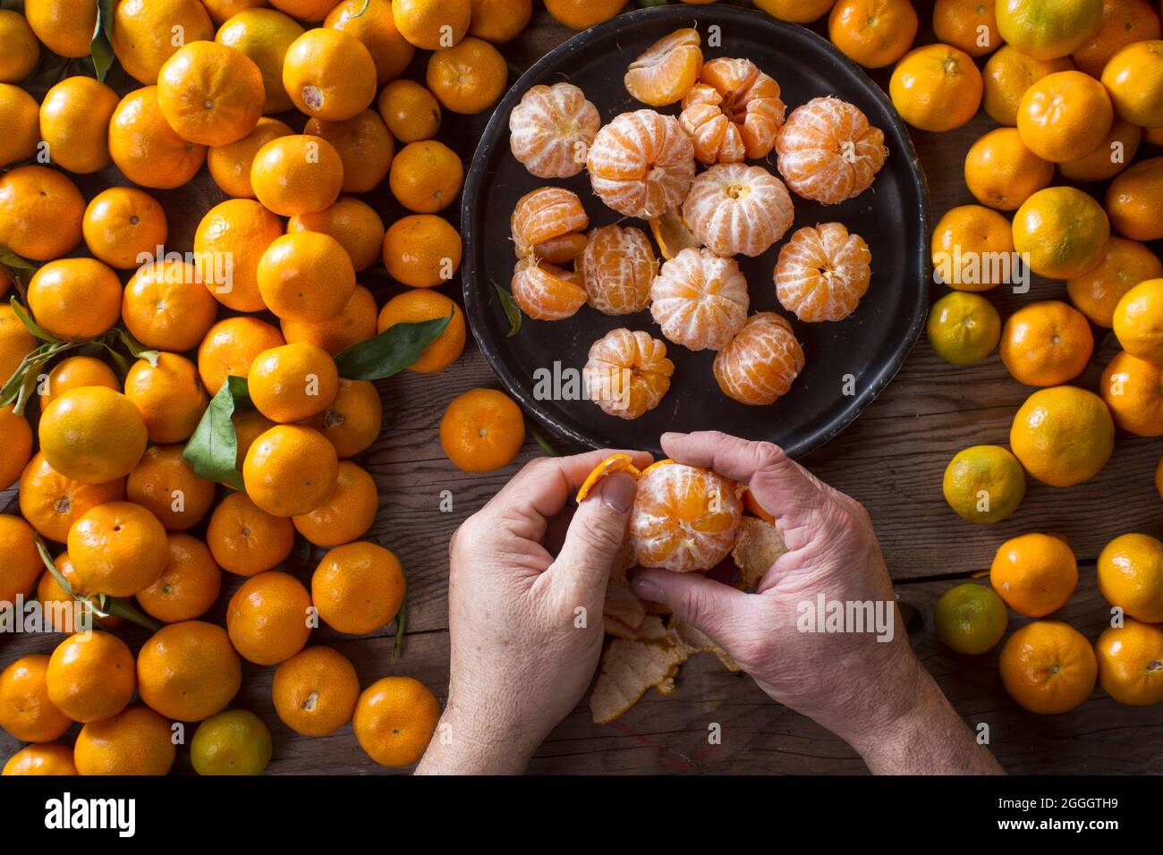 Presentation of Small peeled mandarin oranges on old wooden table Stock ...