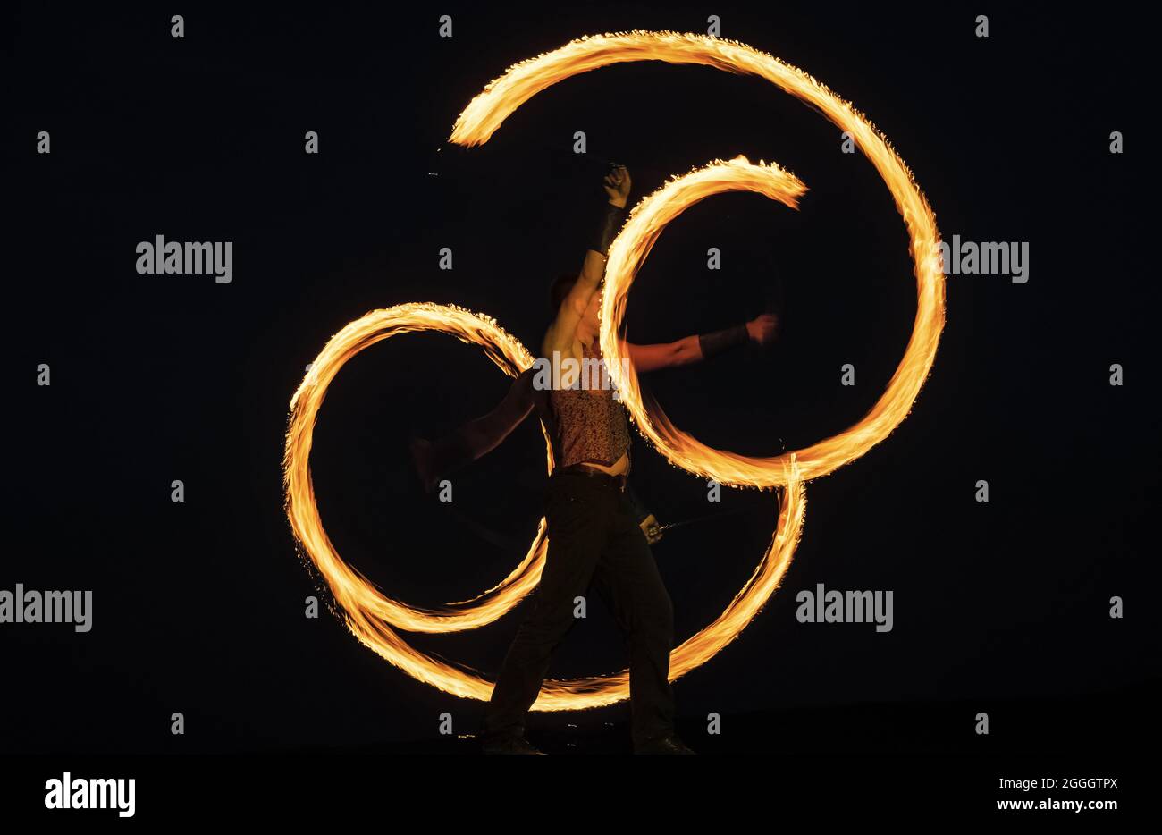 Fire poi artist perform burning reels with glowing, tails in motion on ...