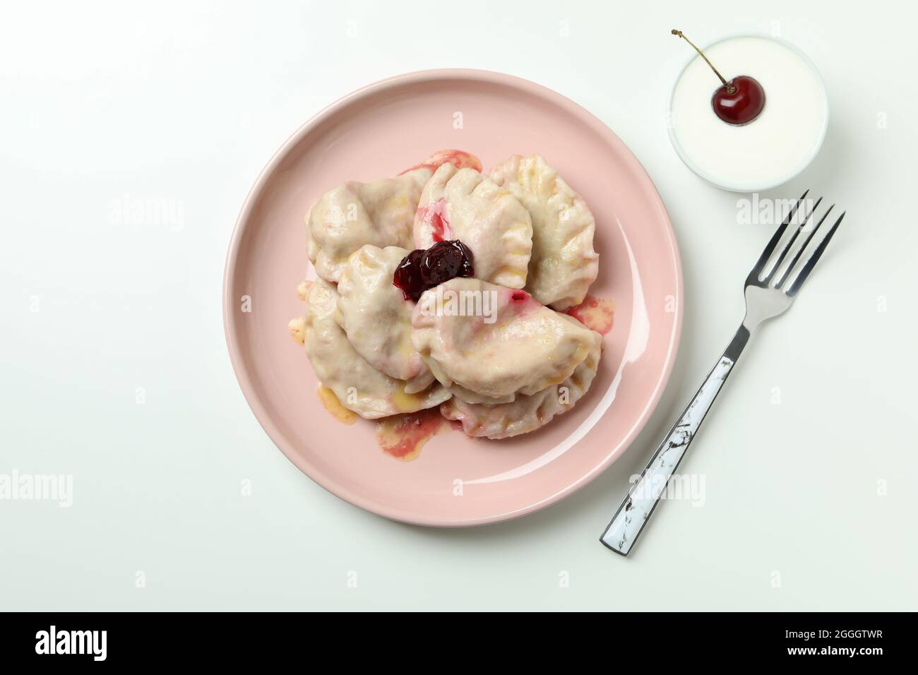 Plate with pierogi with cherry on white background Stock Photo - Alamy