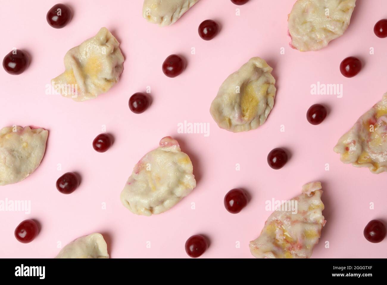 Flat lay with pierogi with cherry on pink background Stock Photo - Alamy