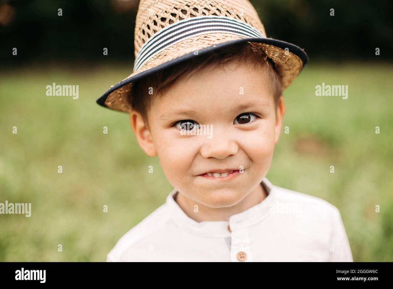Headshot of a cute little preschool boy in summer hat smiling happily ...