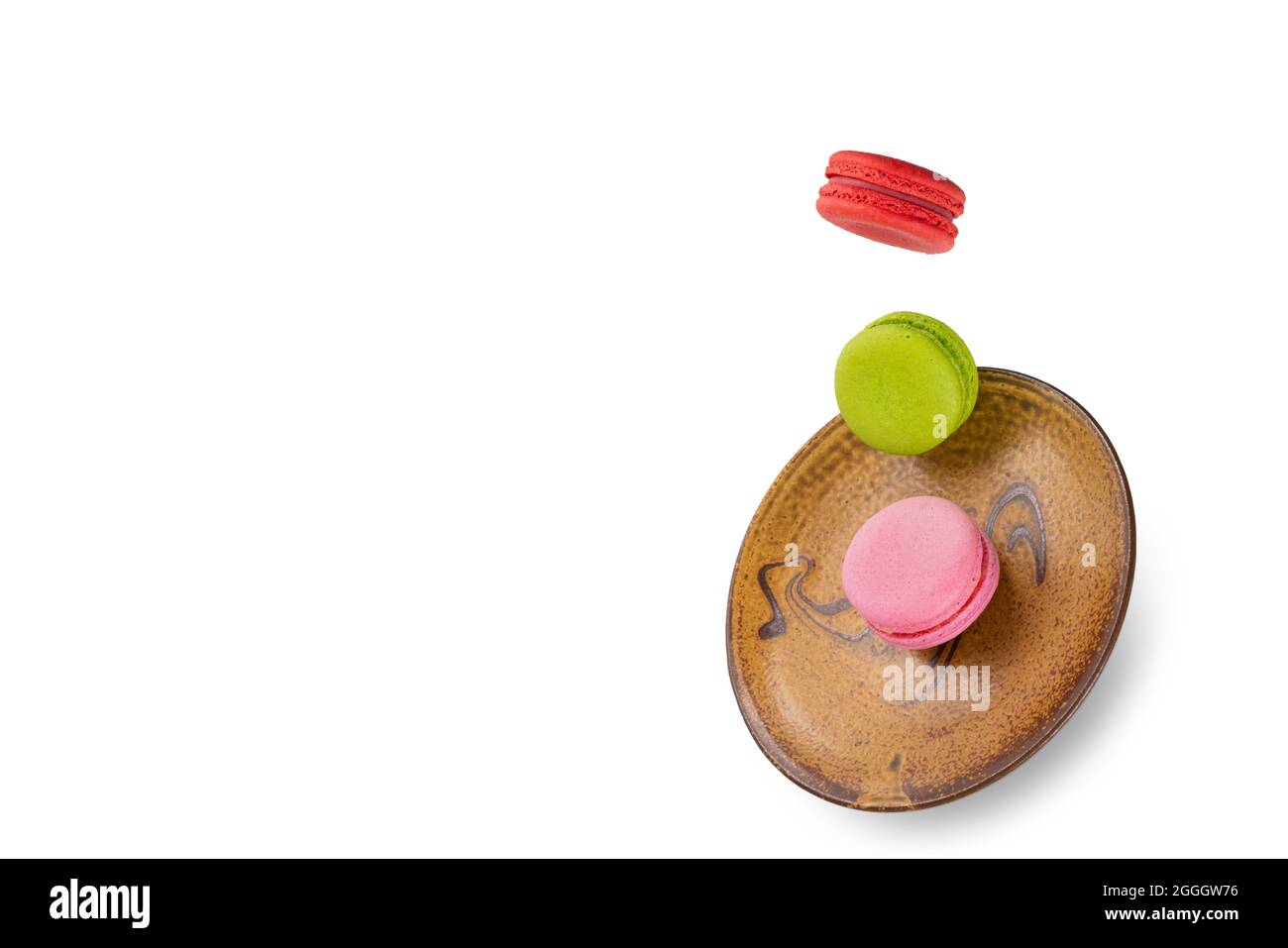 Colorful macaroons levitating on an orange plate. Levitation food ...
