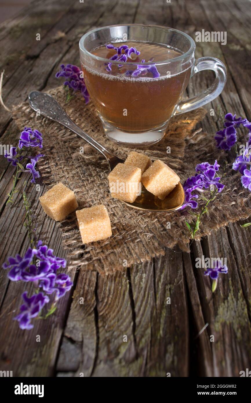 Tea served in a glass cup with garnish flower Duranta repens Stock ...