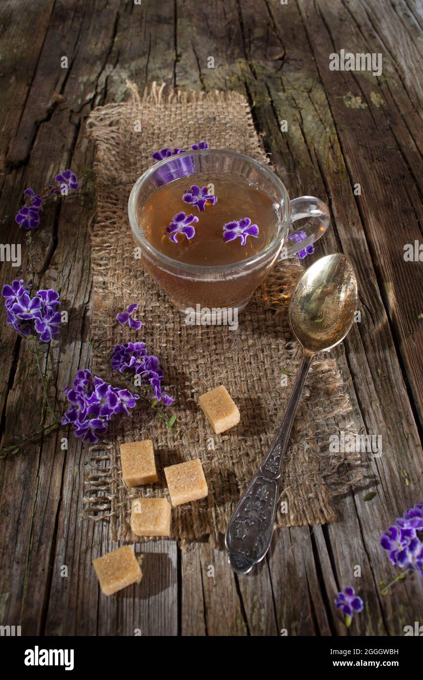 Tea served in a glass cup with garnish flower Duranta repens Stock ...