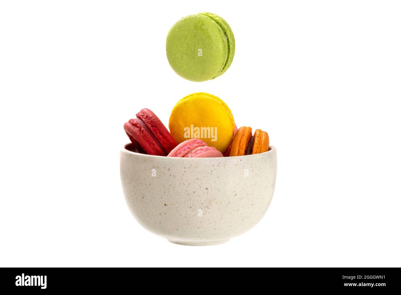 A green macaroon floating on a ceramic bowl full of colorful macaroons ...