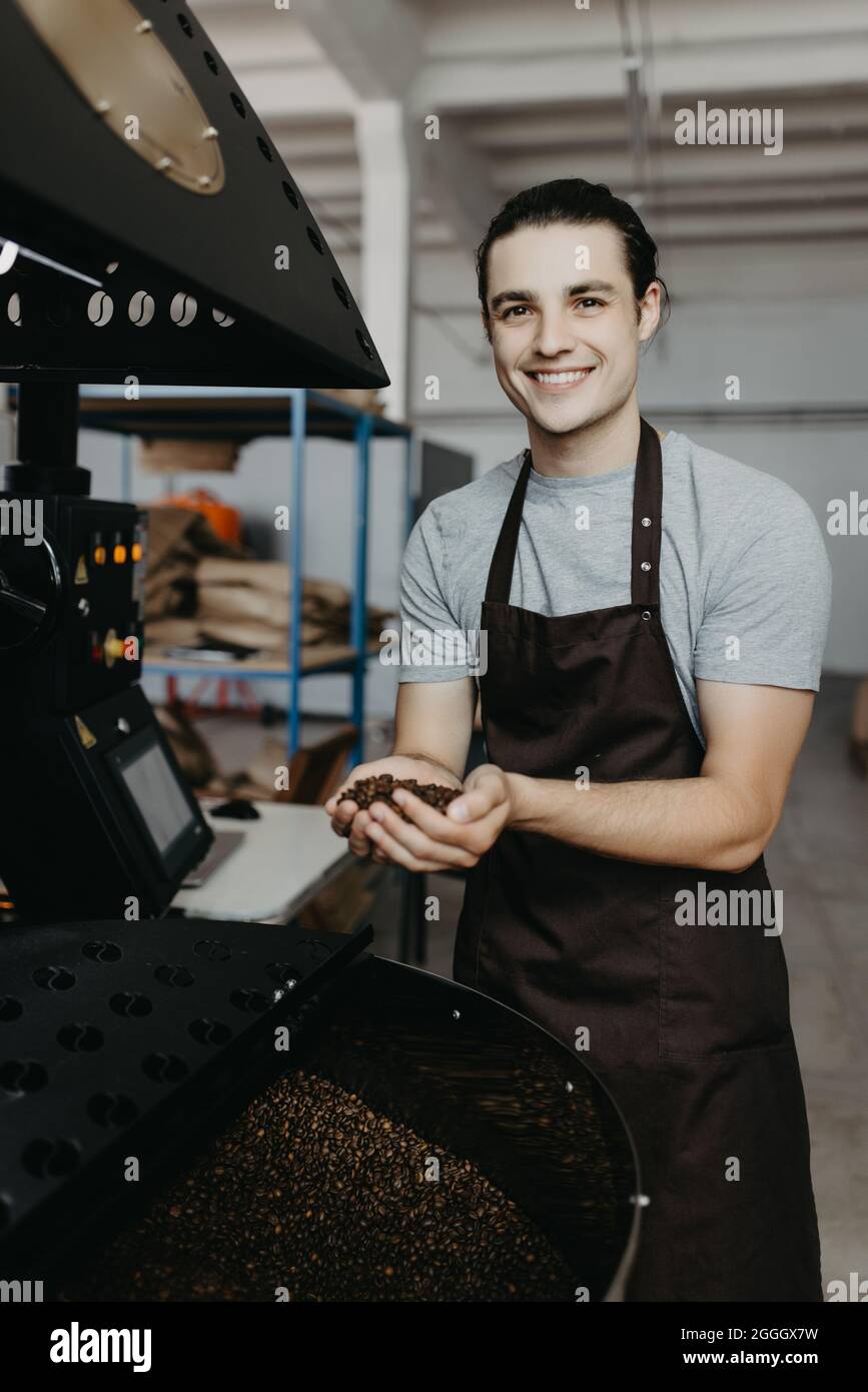 Portrait of cheerful bearded master having job at factory. He ...