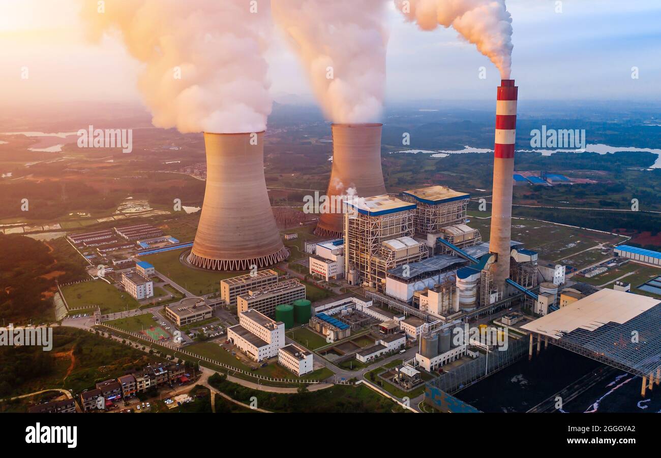 coal fired power station with cooling towers releasing steam into ...