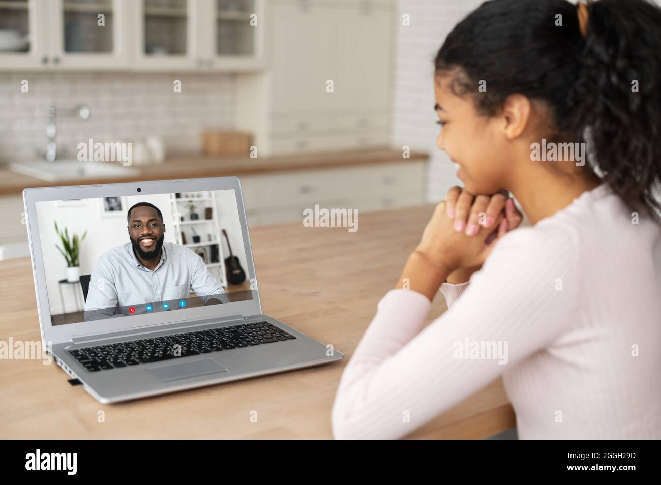 Back view of African-American woman making video call with her male ...