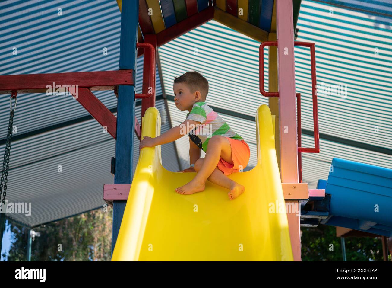 The child is afraid of rolling down the children's slide Stock Photo ...