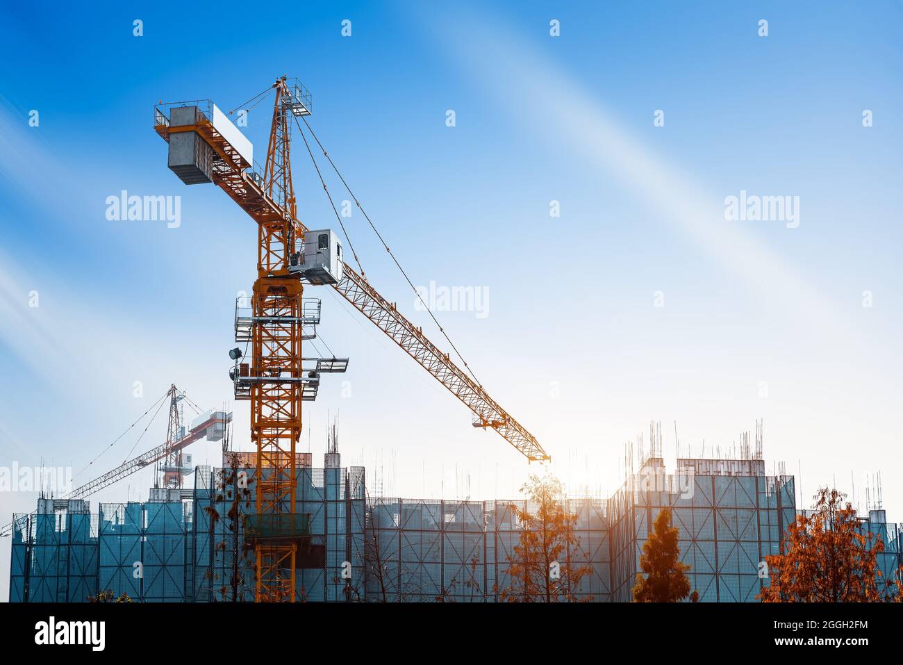 Crane lifting concrete mixer container against blue sky Stock Photo - Alamy
