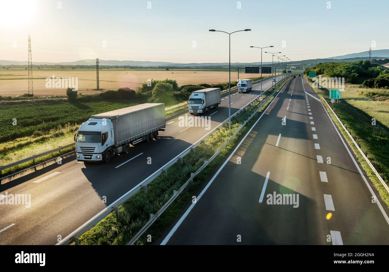 Transportation trucks in line on a country highway Stock Photo - Alamy
