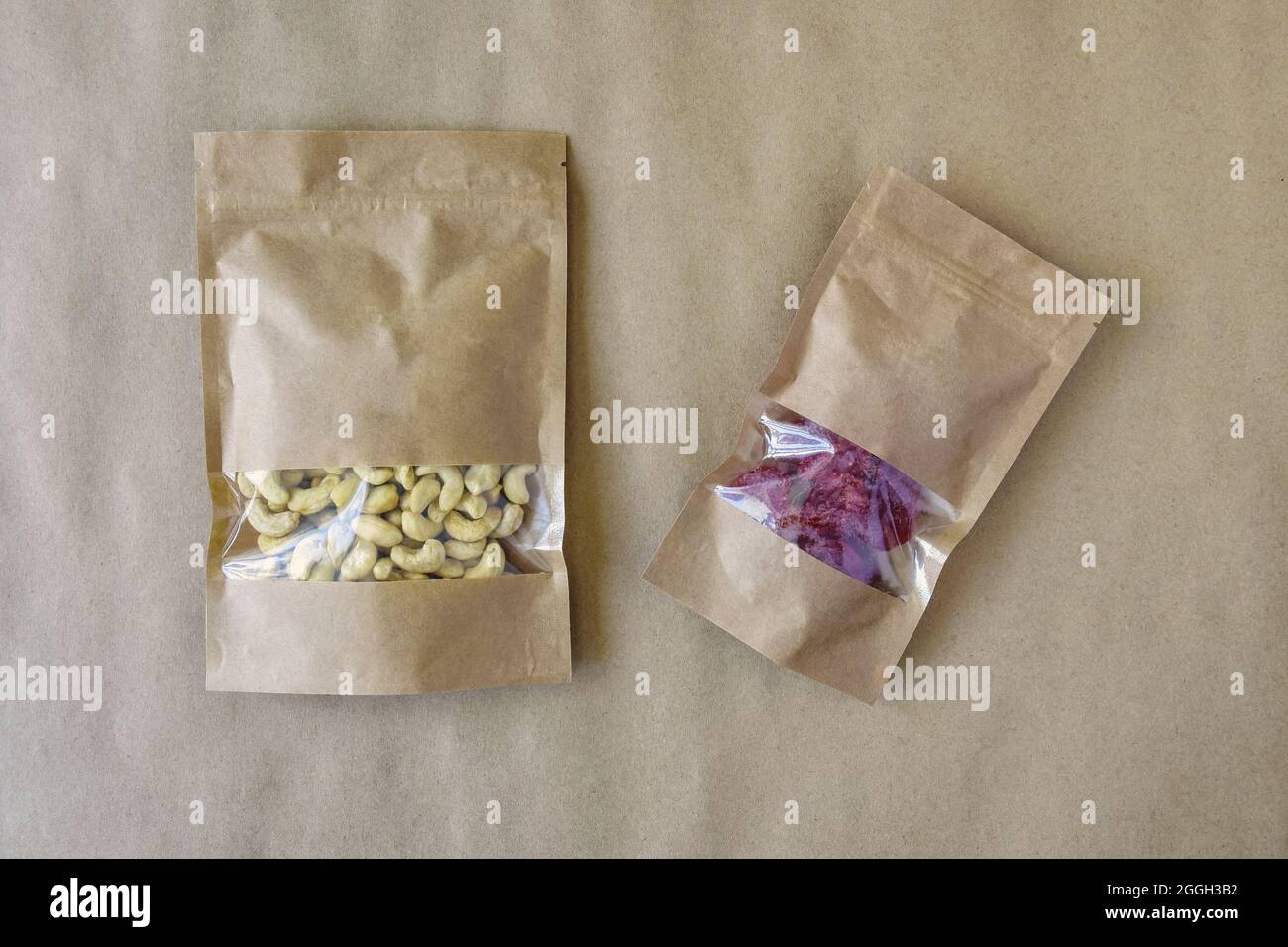 Cashew nuts and dried strawberries in ecological paper packages are on ...