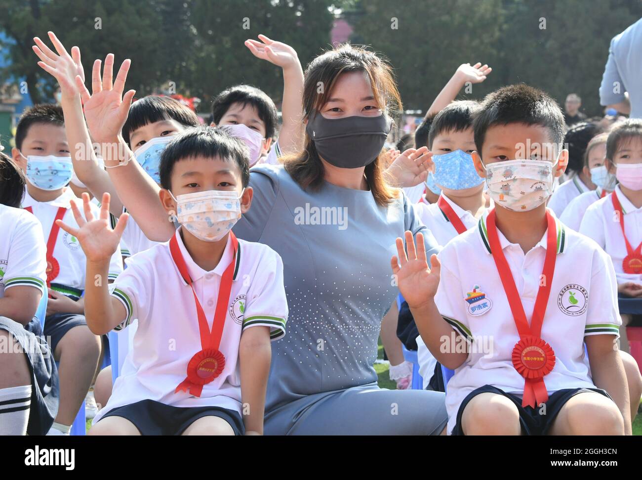 Beijing, China. 1st Sep, 2021. Pupils and a teacher attend the opening ...