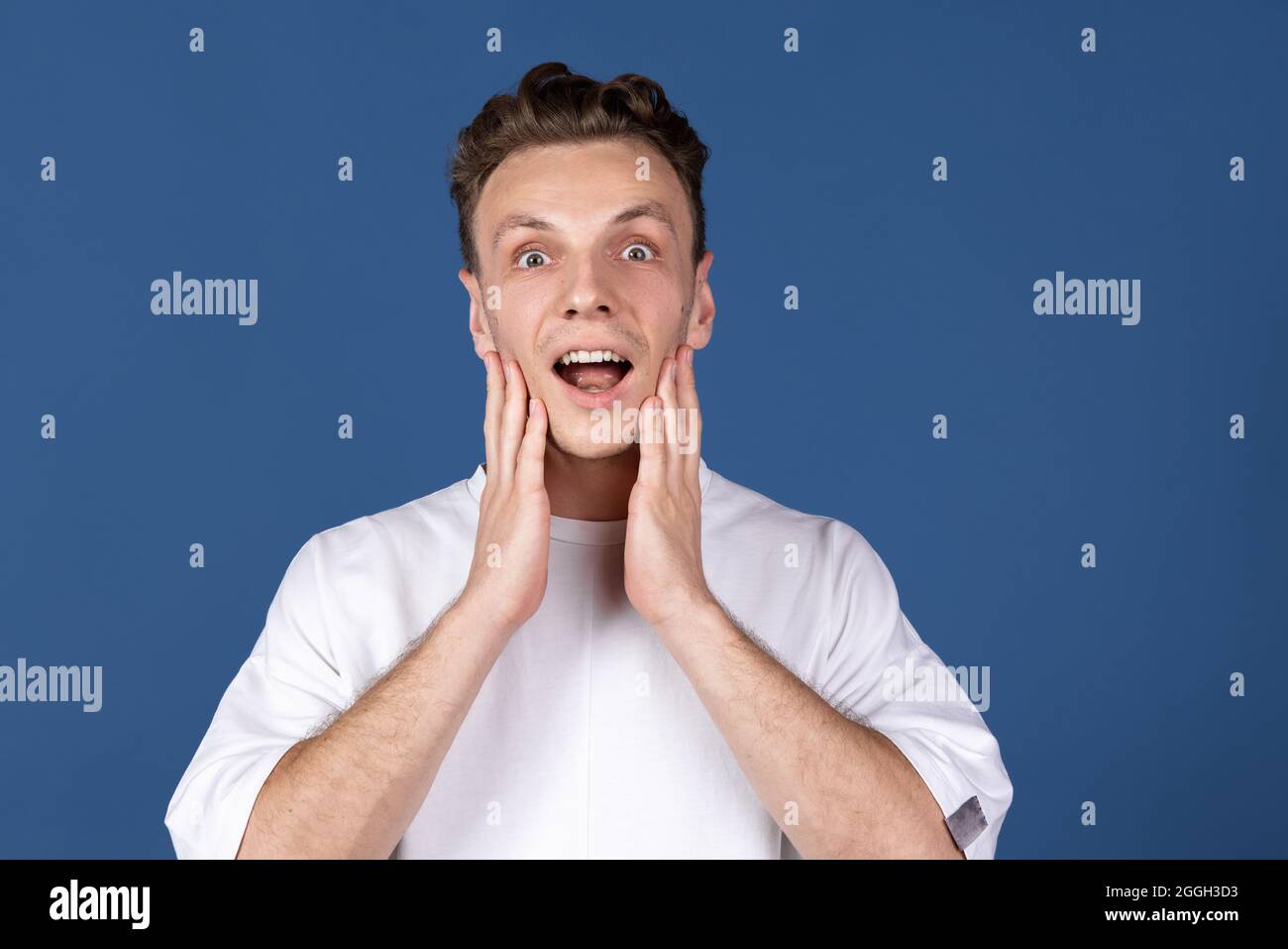 Close-up Caucasian young man with open mouth isolated on navy blue ...