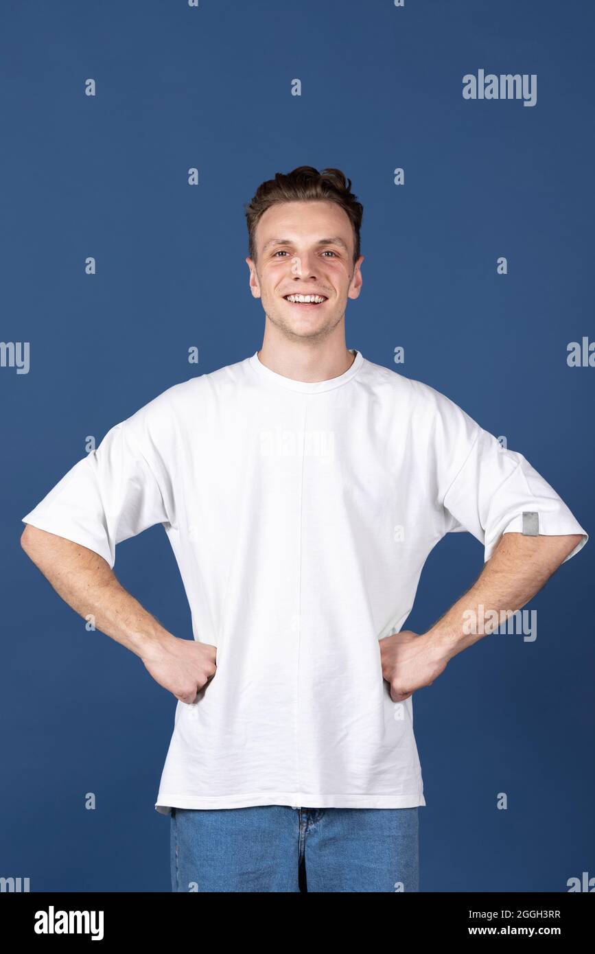 Vertical image of Caucasian young man isolated on blue color studio ...