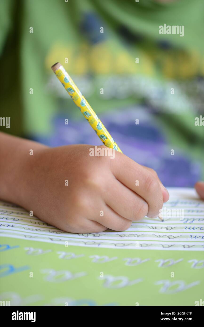 Vertical closeup of a child learning to write letters Stock Photo - Alamy