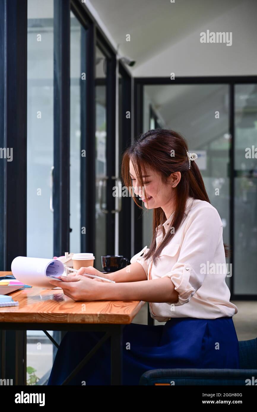 Side view woman accountant checking financial reports at modern office ...