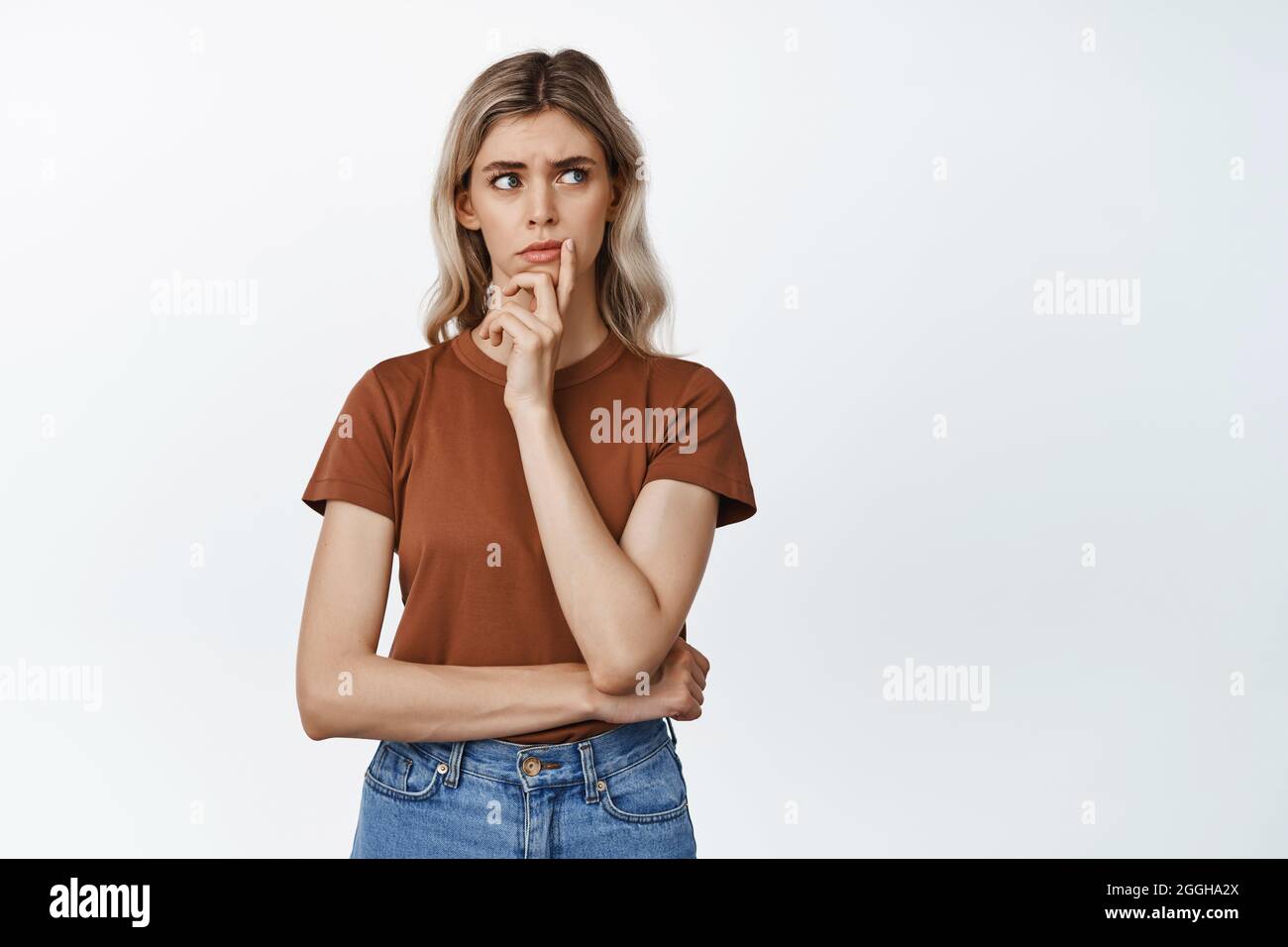 Image of concerned woman looking hesitant aside, thinking of something ...