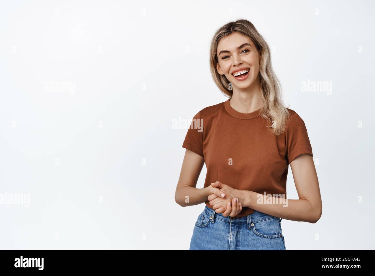 Young smiling woman professional, holding hands together against chest ...