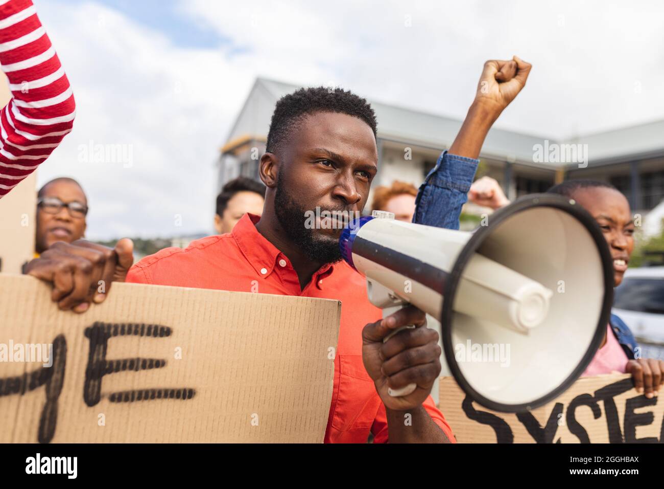 African american man using megaphone and holding placard at a protest ...