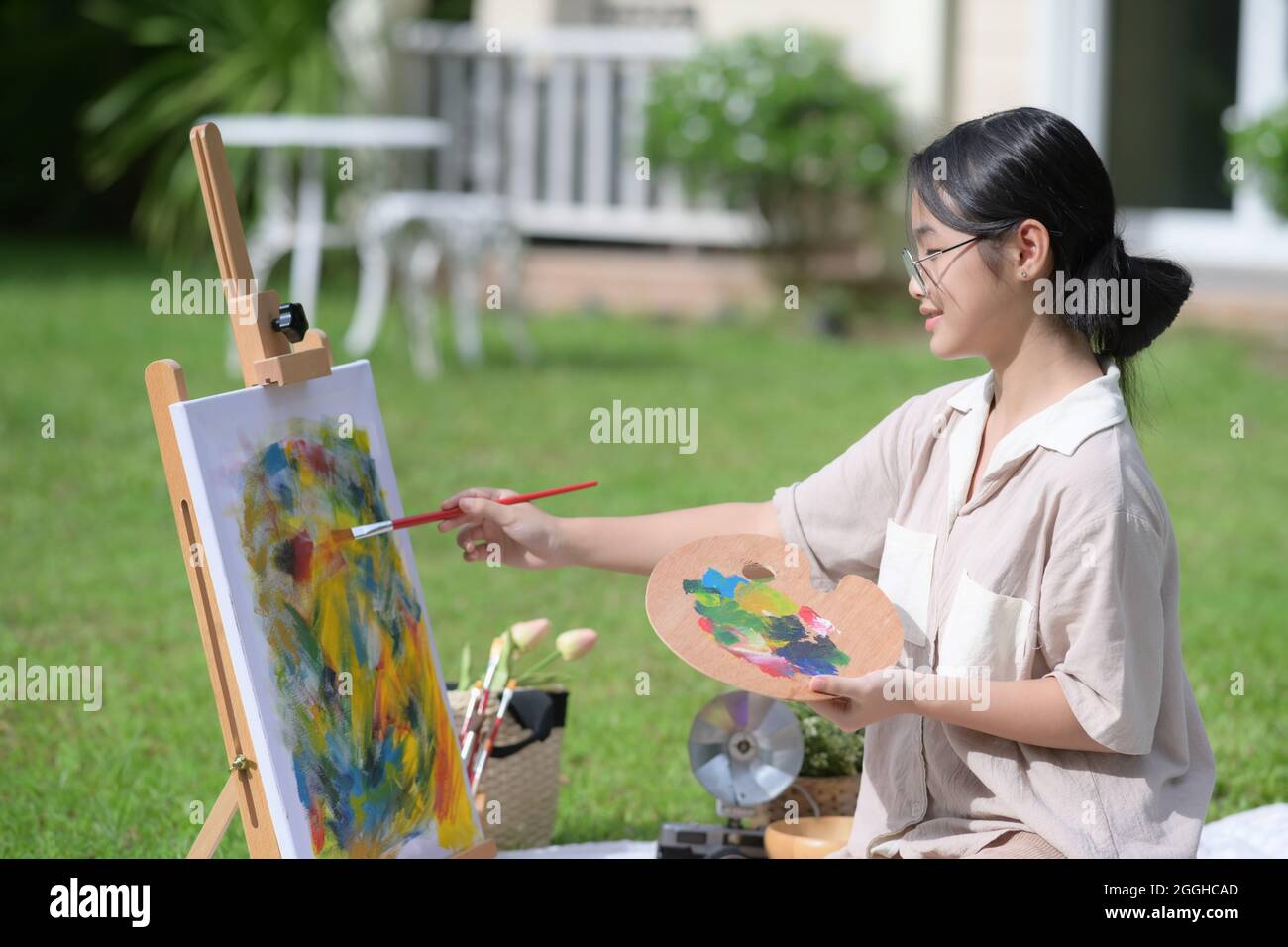 Asian girl having fun painting on easel at outdoor Stock Photo - Alamy