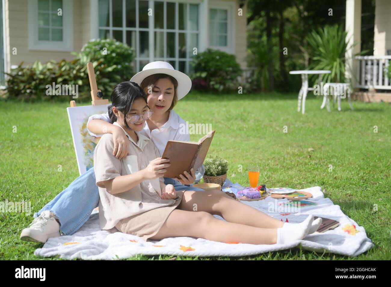 Mom reading book daughter picnic hi-res stock photography and images ...
