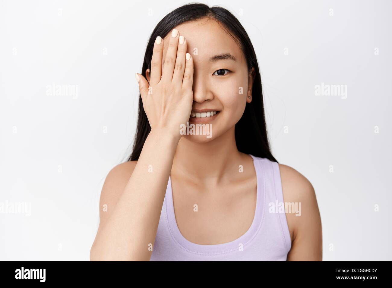 Close up portrait of cute asian girl without makeup, covers one side of ...