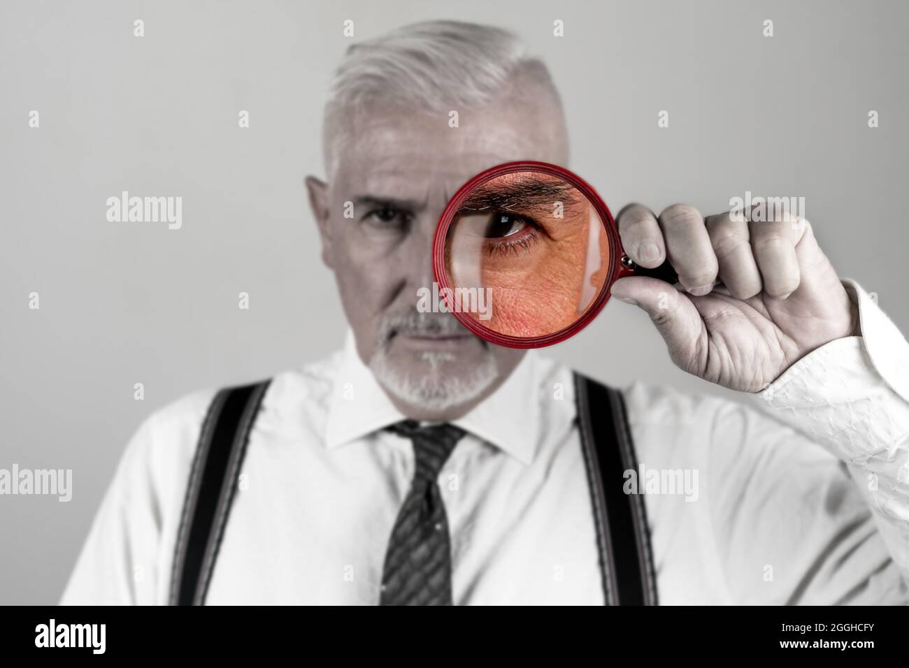portrait of investigator while looking with magnifying glass isolated ...