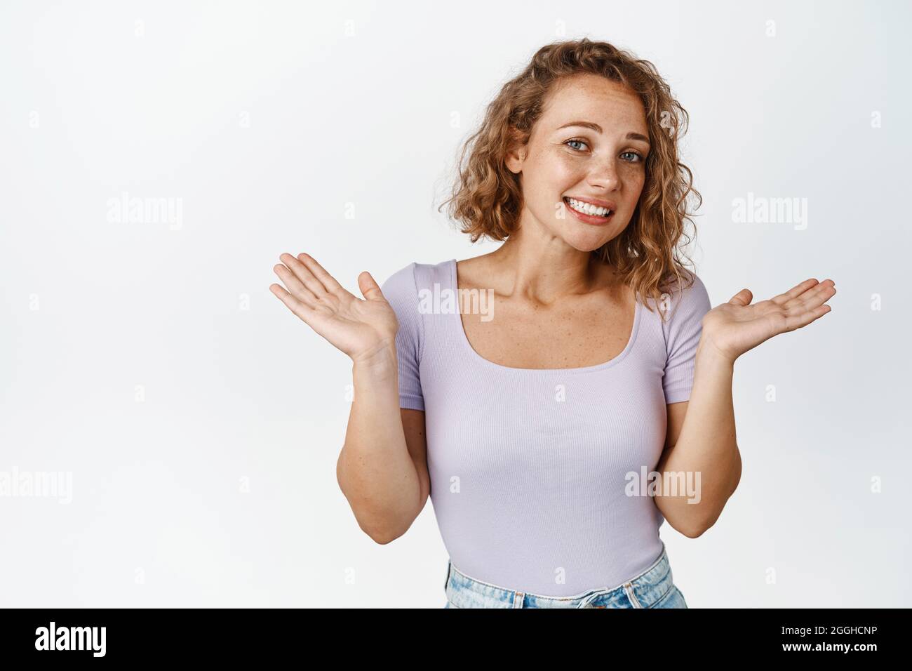 Awkward blond girl say sorry with shoulder shrug, feeling uncomfortable ...