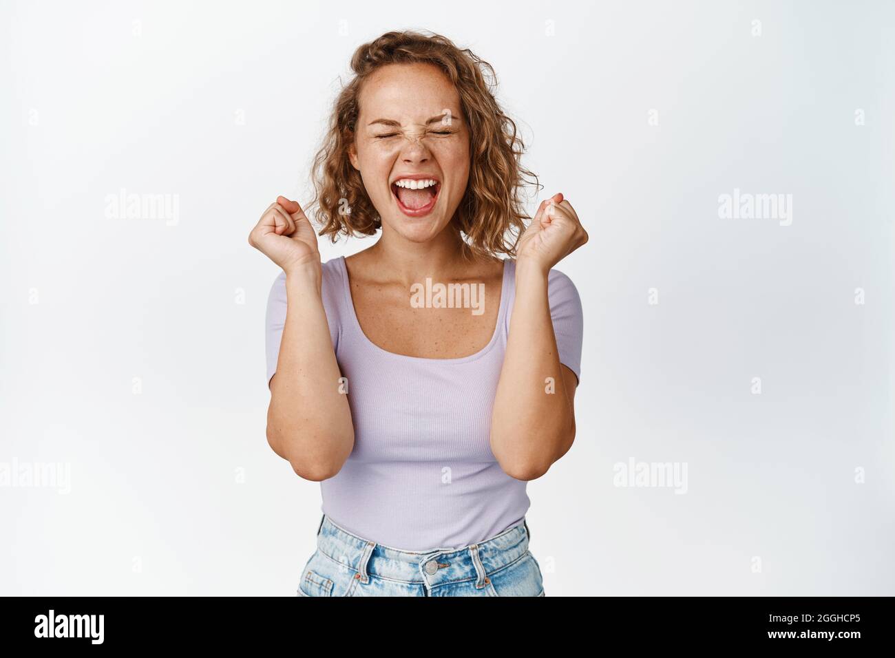 Excited blond woman screaming and looking pumped, stoked about ...